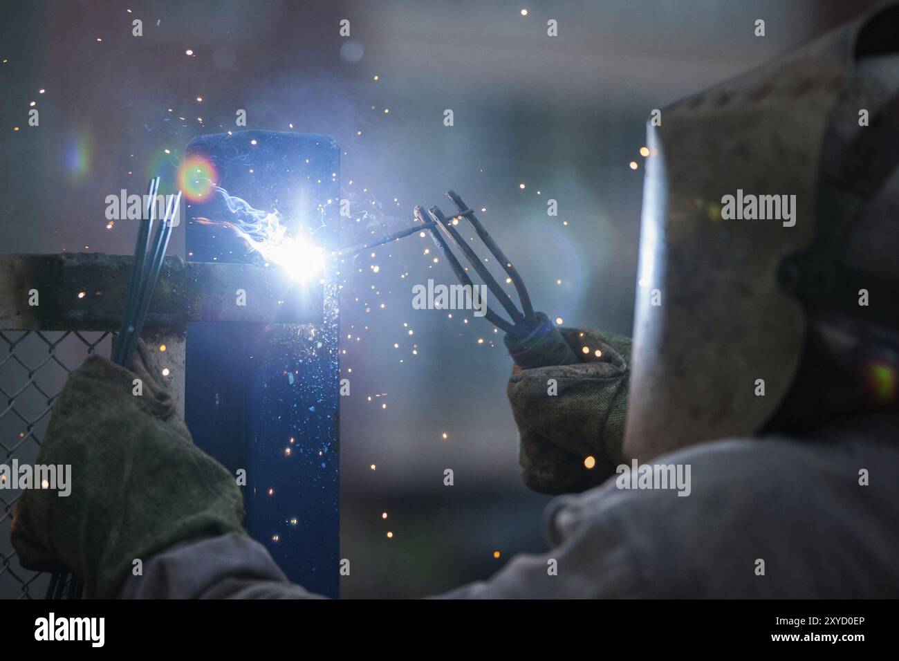 Heavy industry welder worker in protective mask hand holding arc ...