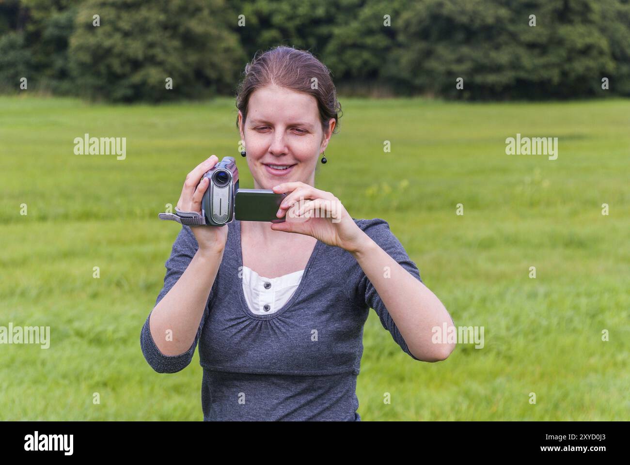 Young woman filming with a camcorder/ handycam Stock Photo - Alamy