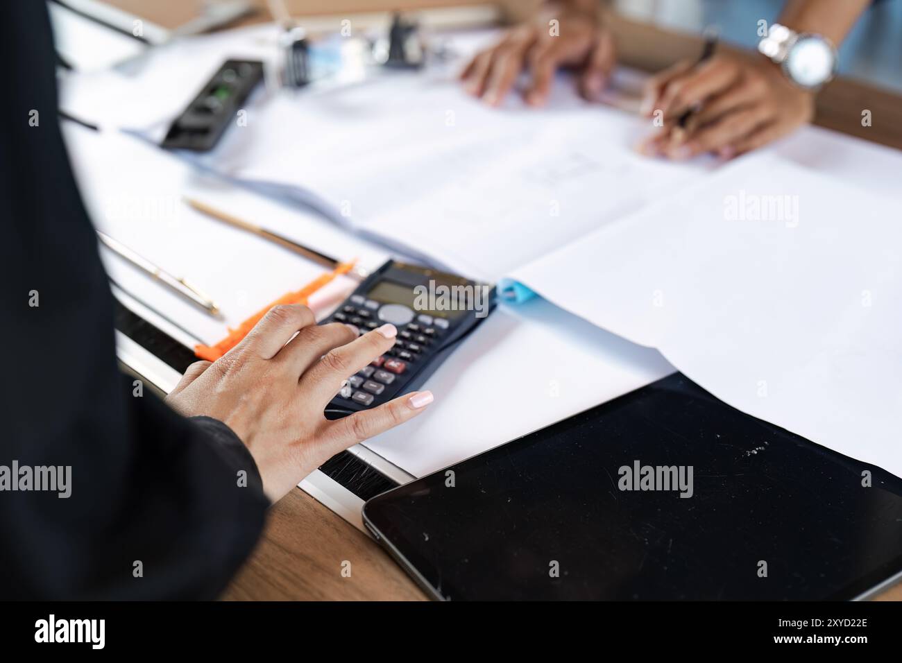 Engineer Working on Blueprints and Calculations with Calculator and ...