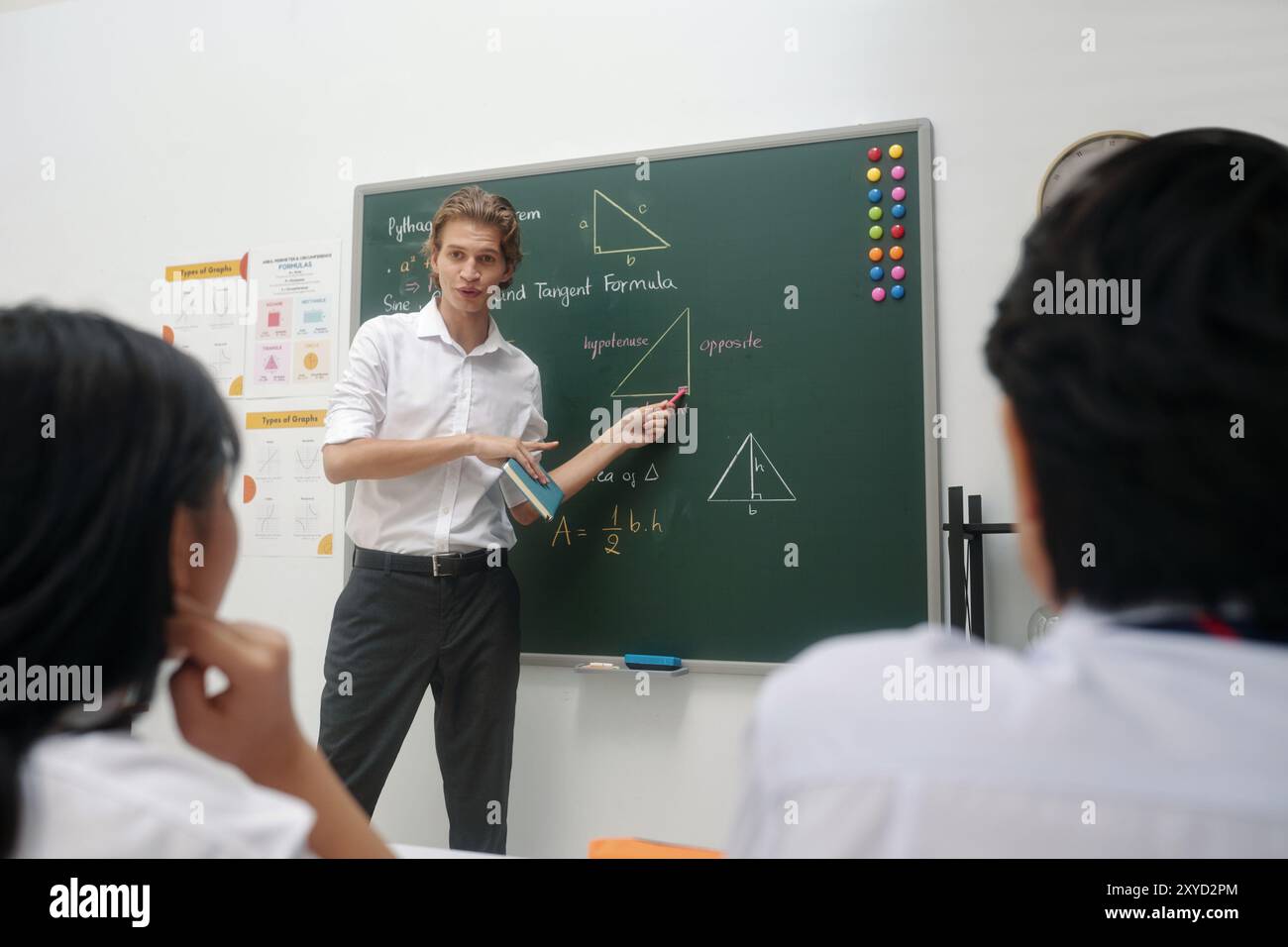 Teacher explaining trigonometric formulas on chalkboard in classroom ...