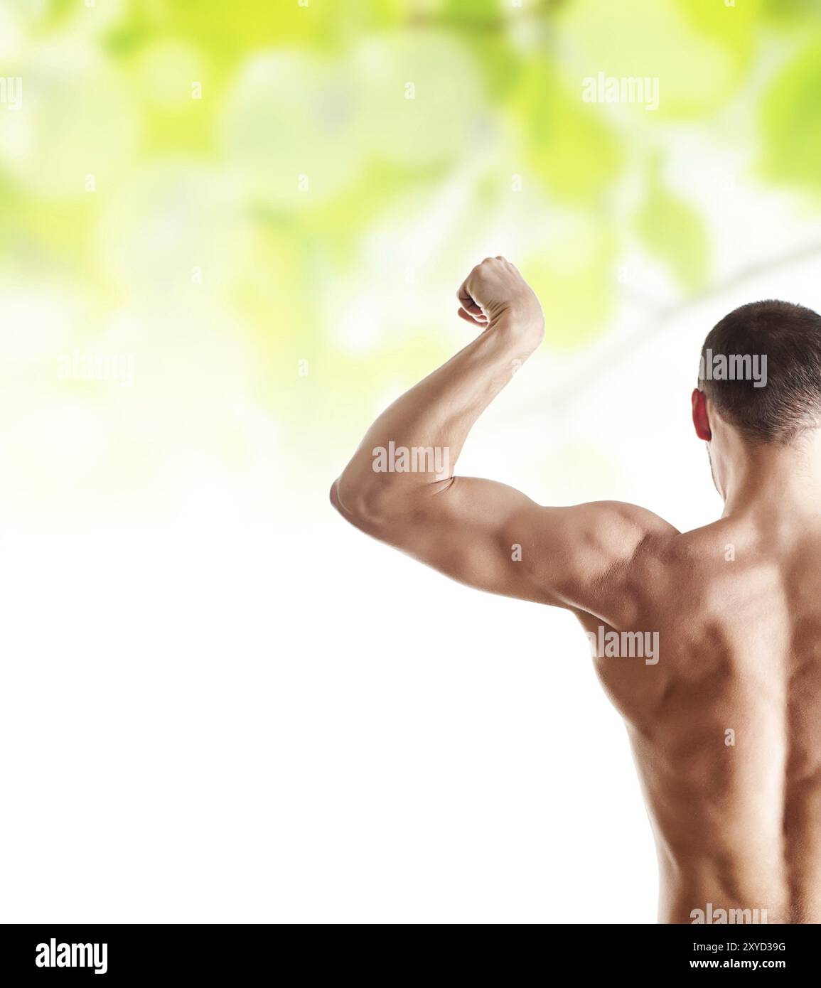 Bodybuilder showing his biceps over green spring healthcare background ...