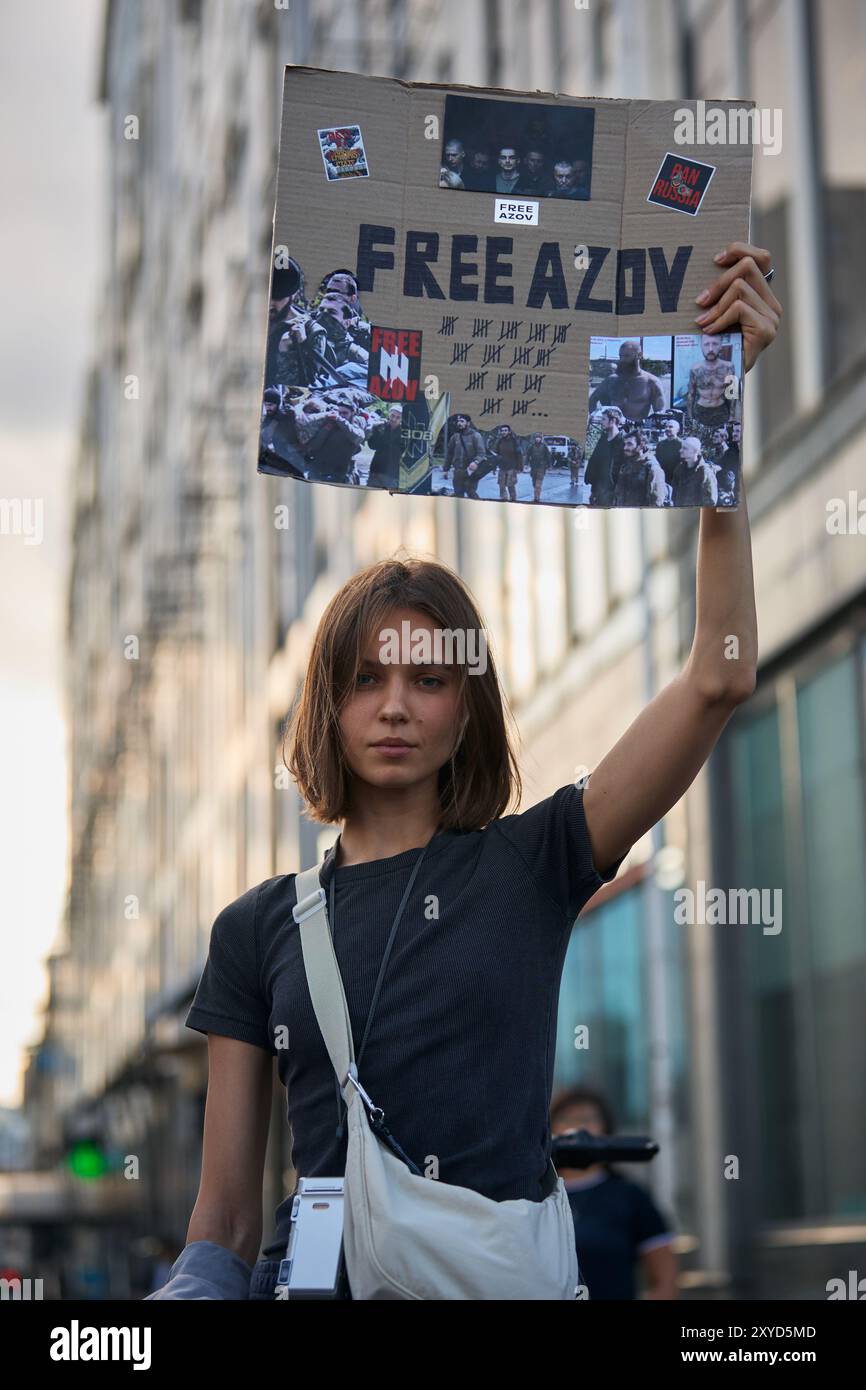Young Ukrainian girl demonstrating with a banner "Free Azov" on a ...