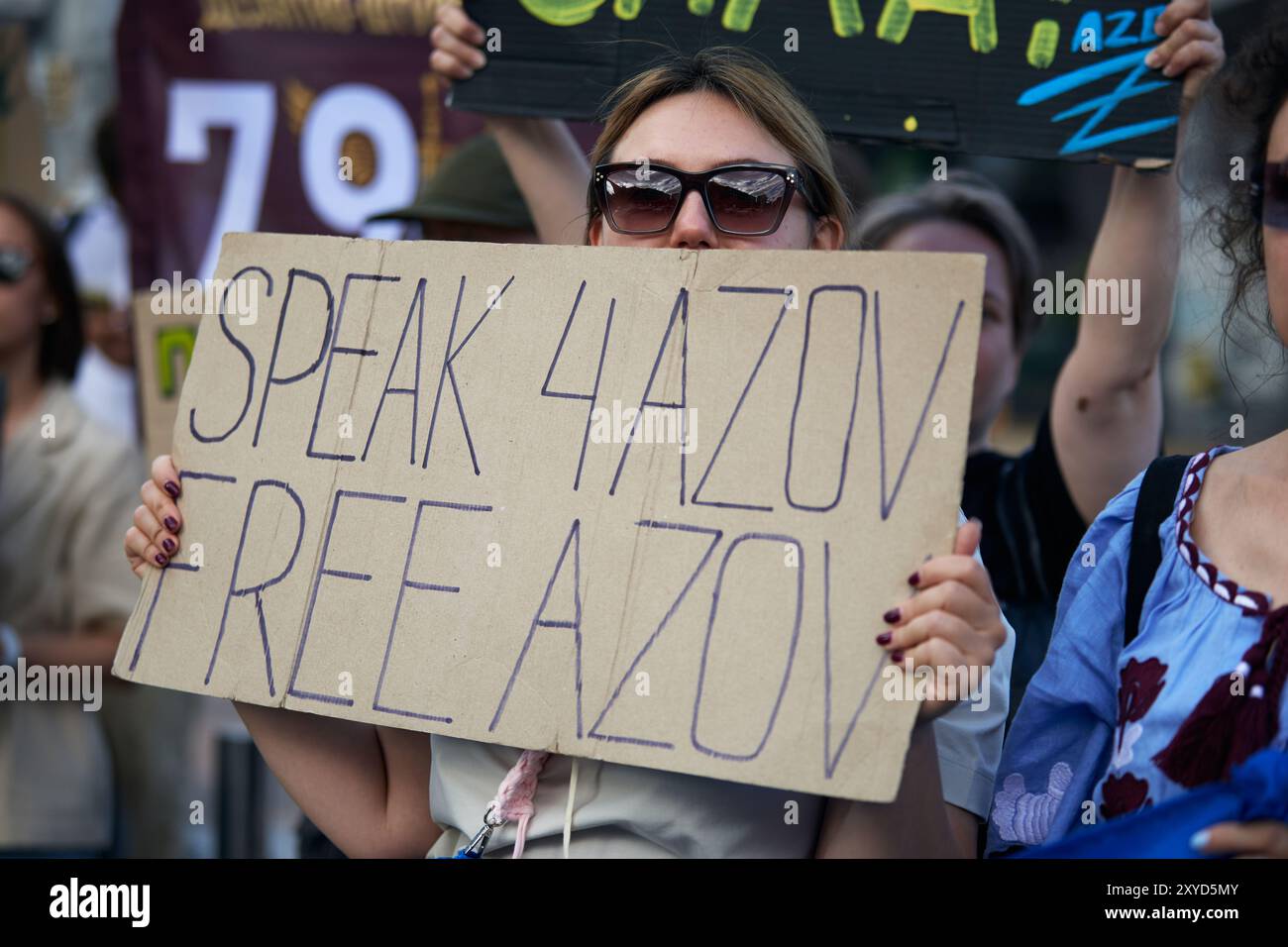 Ukrainian woman posing with a sign "Speak For Azov. Free Azov" on a ...