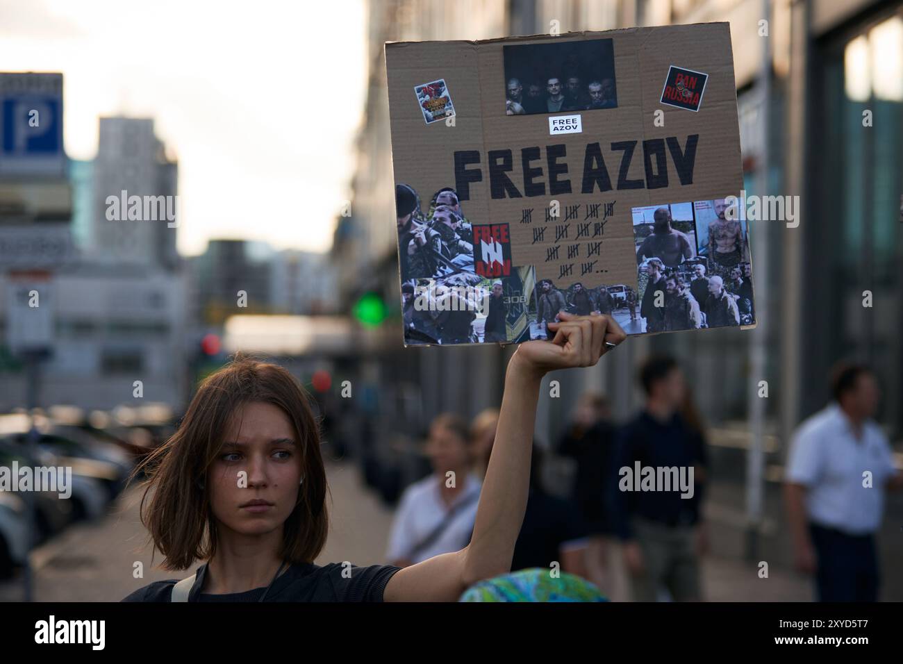 Young Ukrainian girl demonstrating with a sign "Free Azov" in center of ...