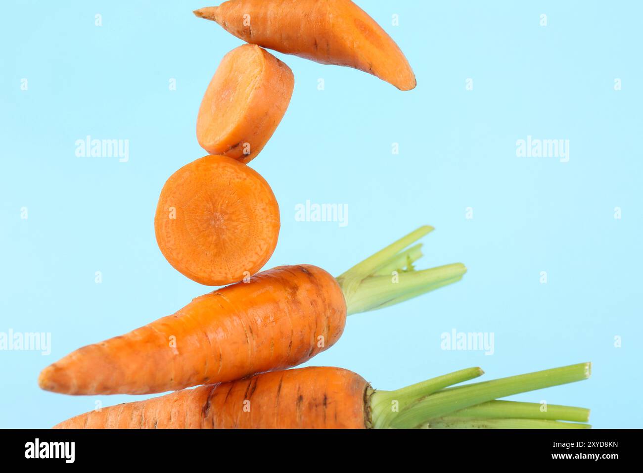Whole and cut fresh carrots on light blue background, closeup Stock ...