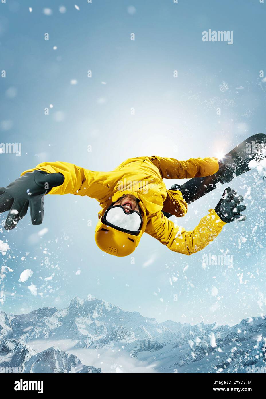 Snowboarder in bright yellow gear in upside down pose in motion ...