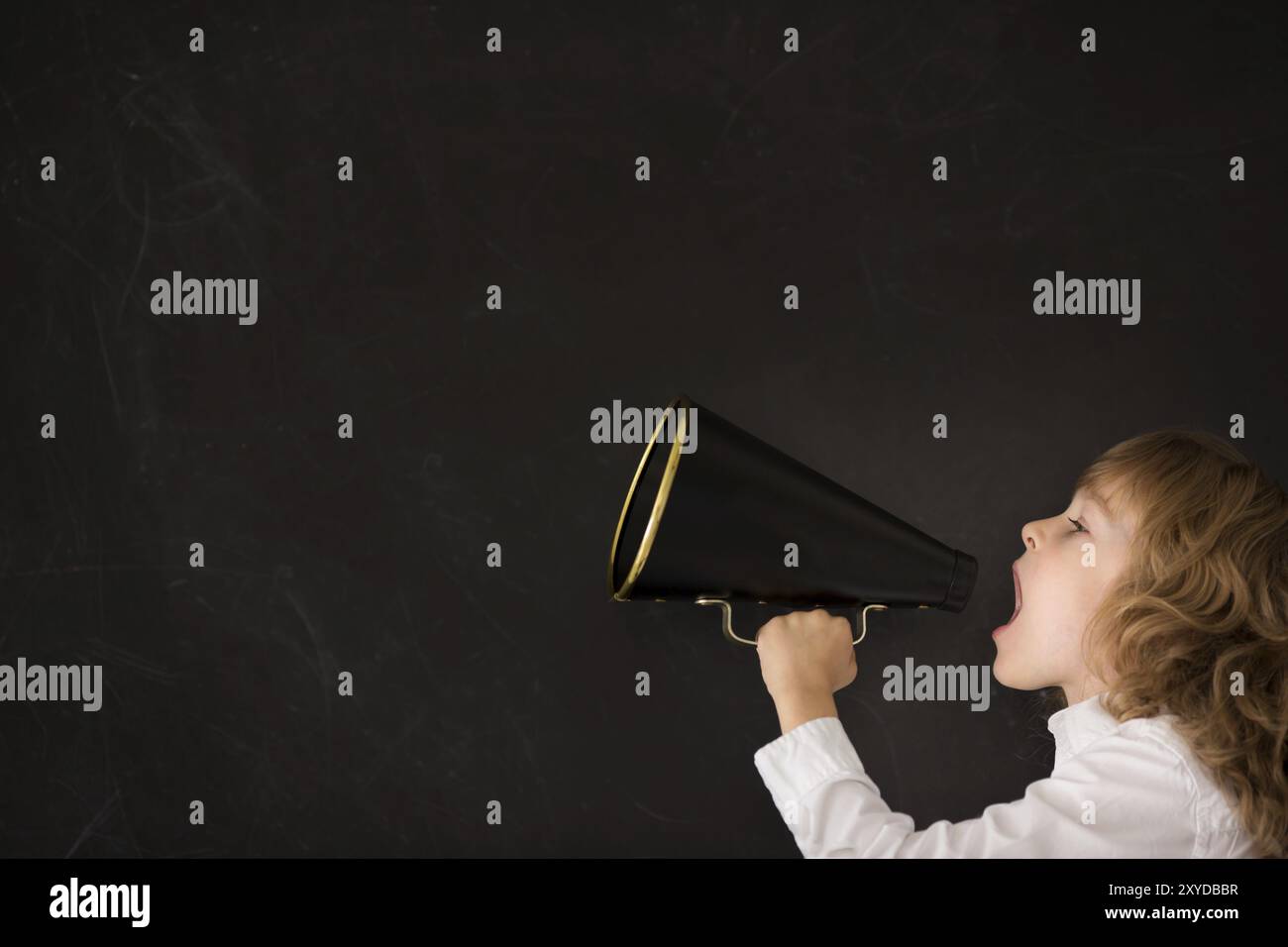 Kid shouting through vintage megaphone against blackboard Stock Photo ...