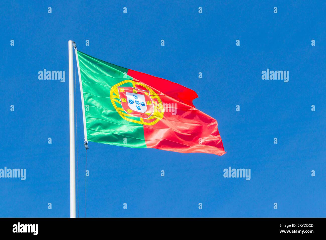 Portuguese national flag waving against a clear blue sky Stock Photo ...