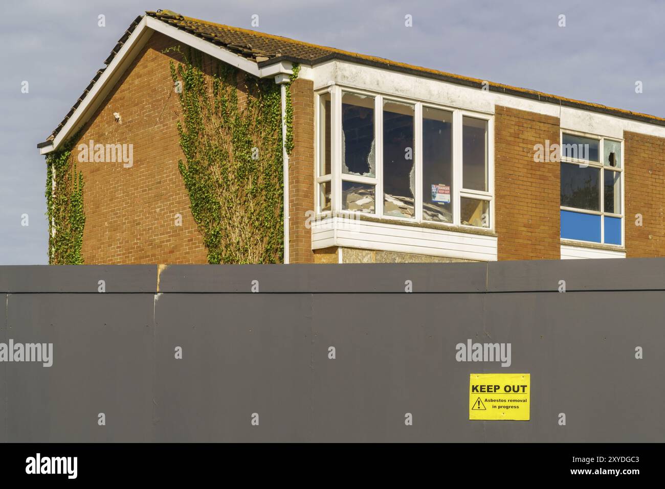 Exmouth, Devon, UK, April 18, 2017: Fence around a house with a sign Asbestos removal in ...