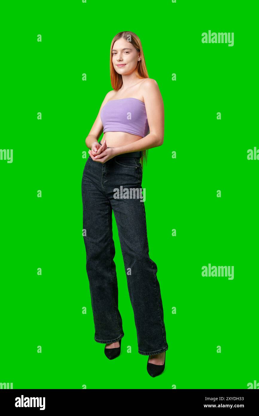 Woman Wearing Black Jeans and a Purple Top Posing in Front of a Green ...