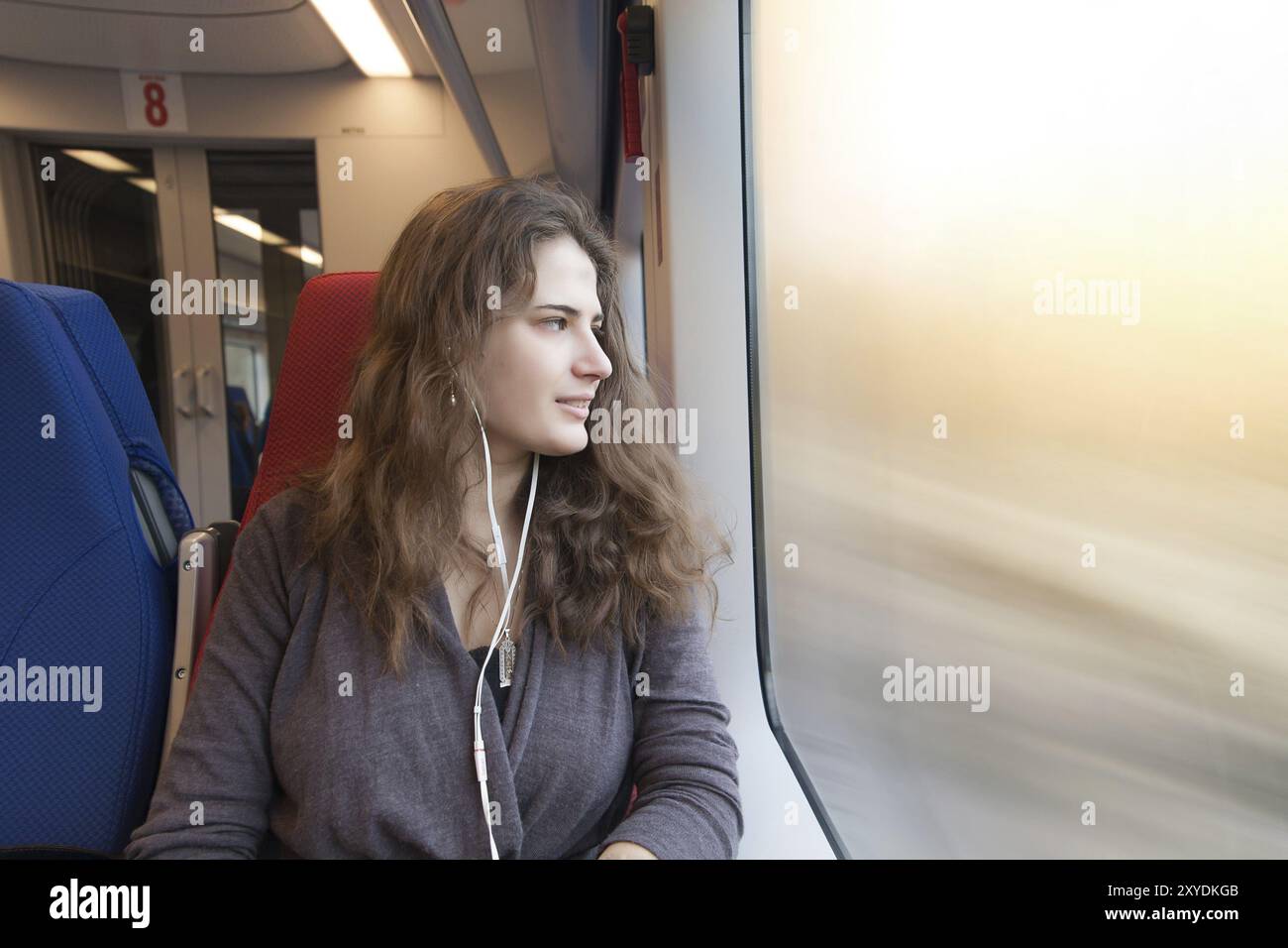 Woman looks out the window while sitting in the train Stock Photo - Alamy