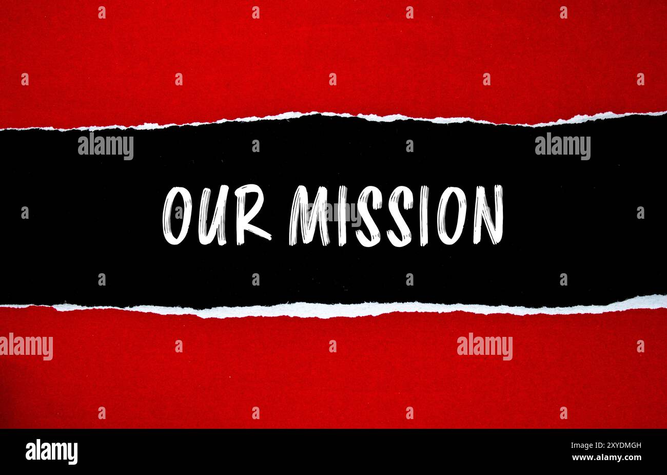 Our mission message written on ripped torn red paper with black background. Conceptual our ...