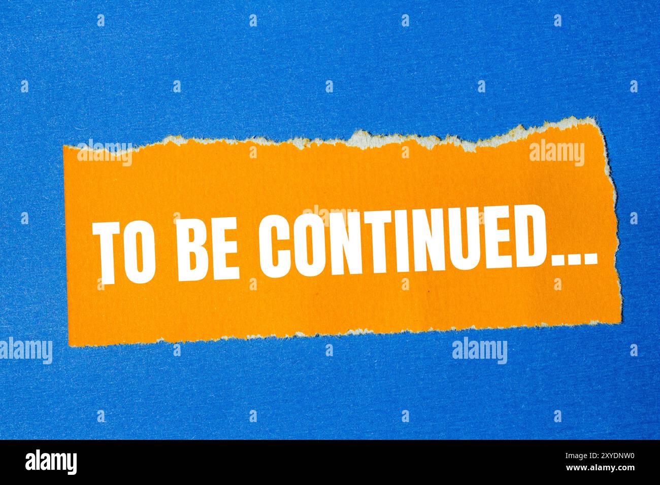 To be continued message written on ripped torn orange paper with blue background. Conceptual to ...