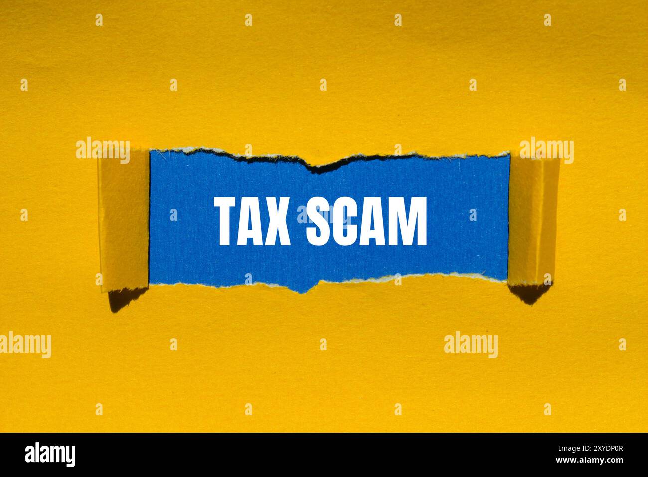 Tax scam message written on ripped torn yellow paper with blue ...