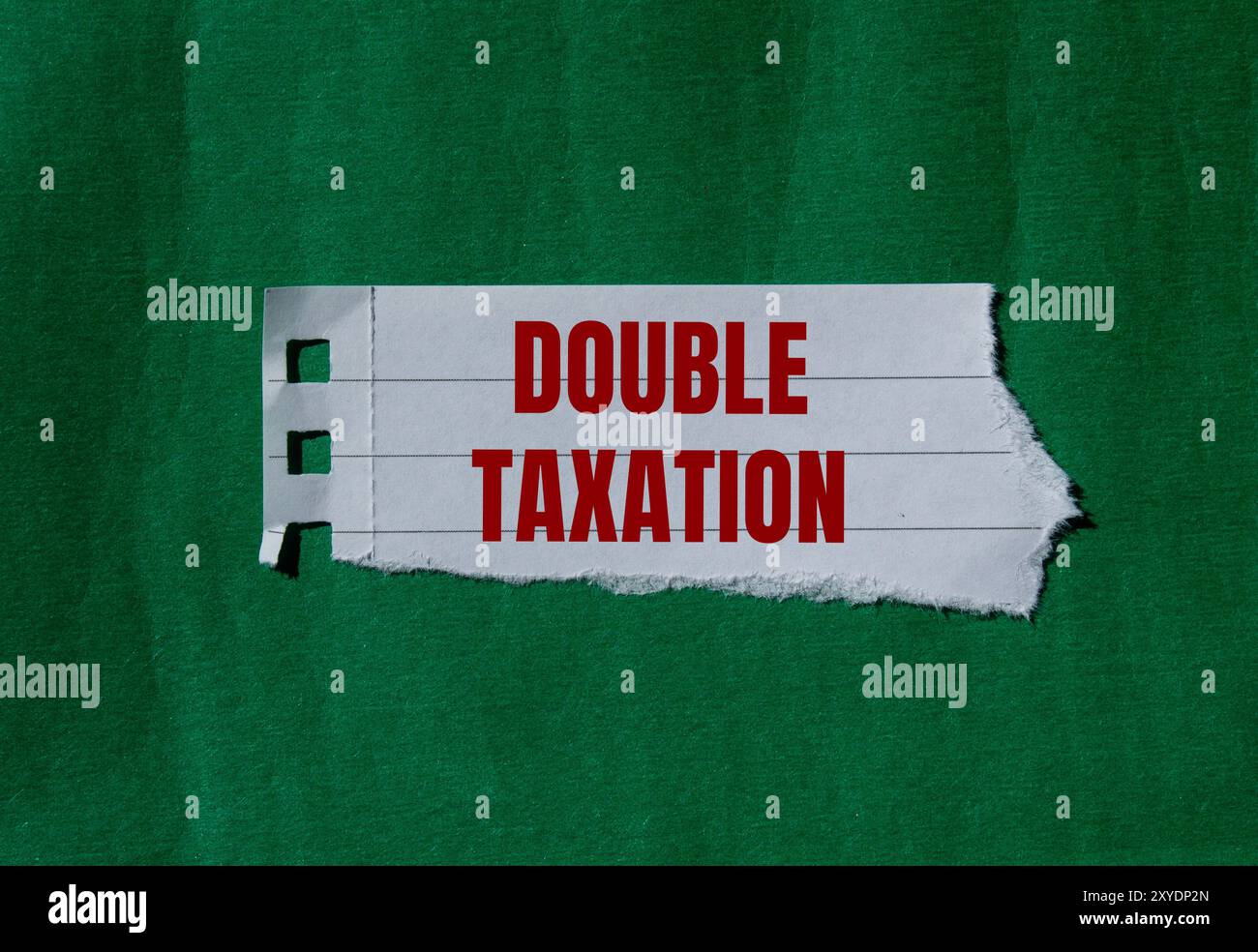 Double taxation message written on ripped torn paper with green background. Conceptual double ...