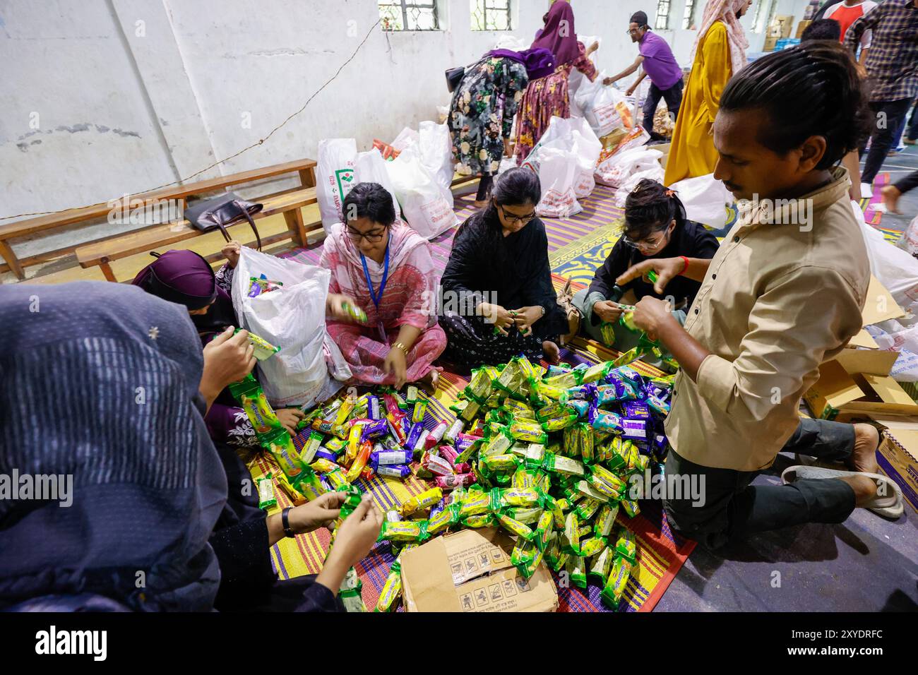 Student volunteers stocking, sorting and packaging relief materials in ...