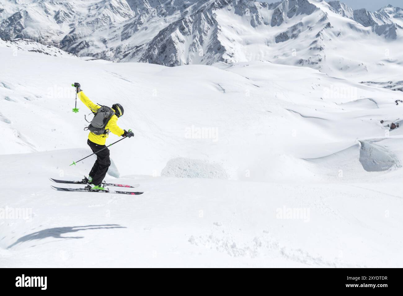 A skier in full sports equipment jumps into the abyss from the top of ...
