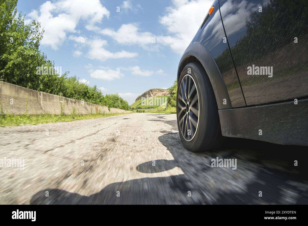 A close-up of the side of the car and a spinning wheel that rides along ...