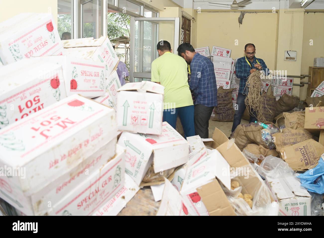 Government officials and workers are preparing food packets to be ...