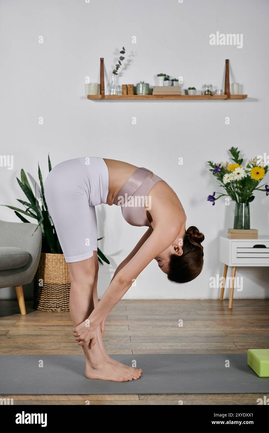 A young woman in a crop top bends forward, stretching her hamstrings on ...
