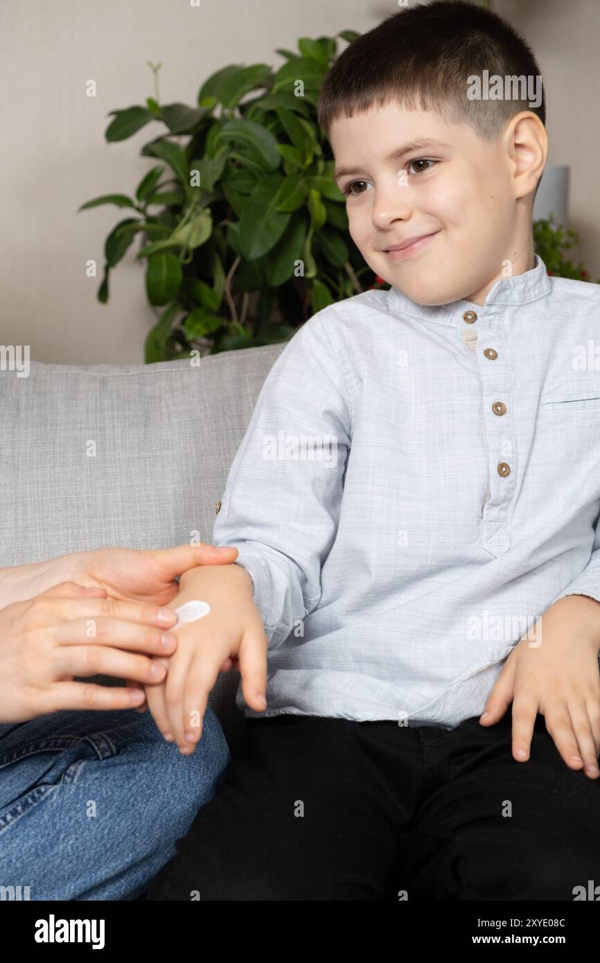 Mom applies cosmetic cream to the hand of a child. Skin care and ...