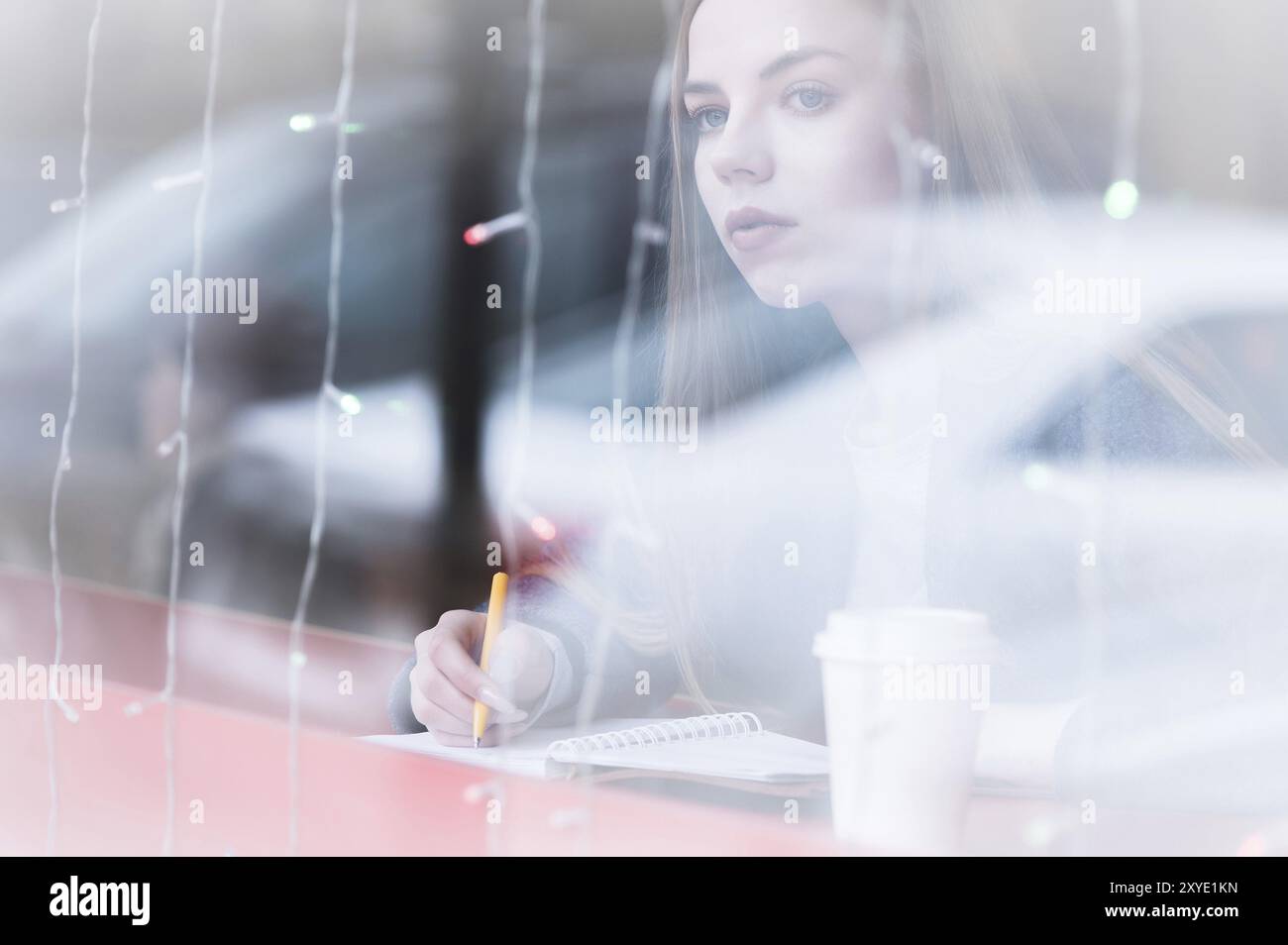 Portrait of an attractive young journalist girl with pen and notepad in ...
