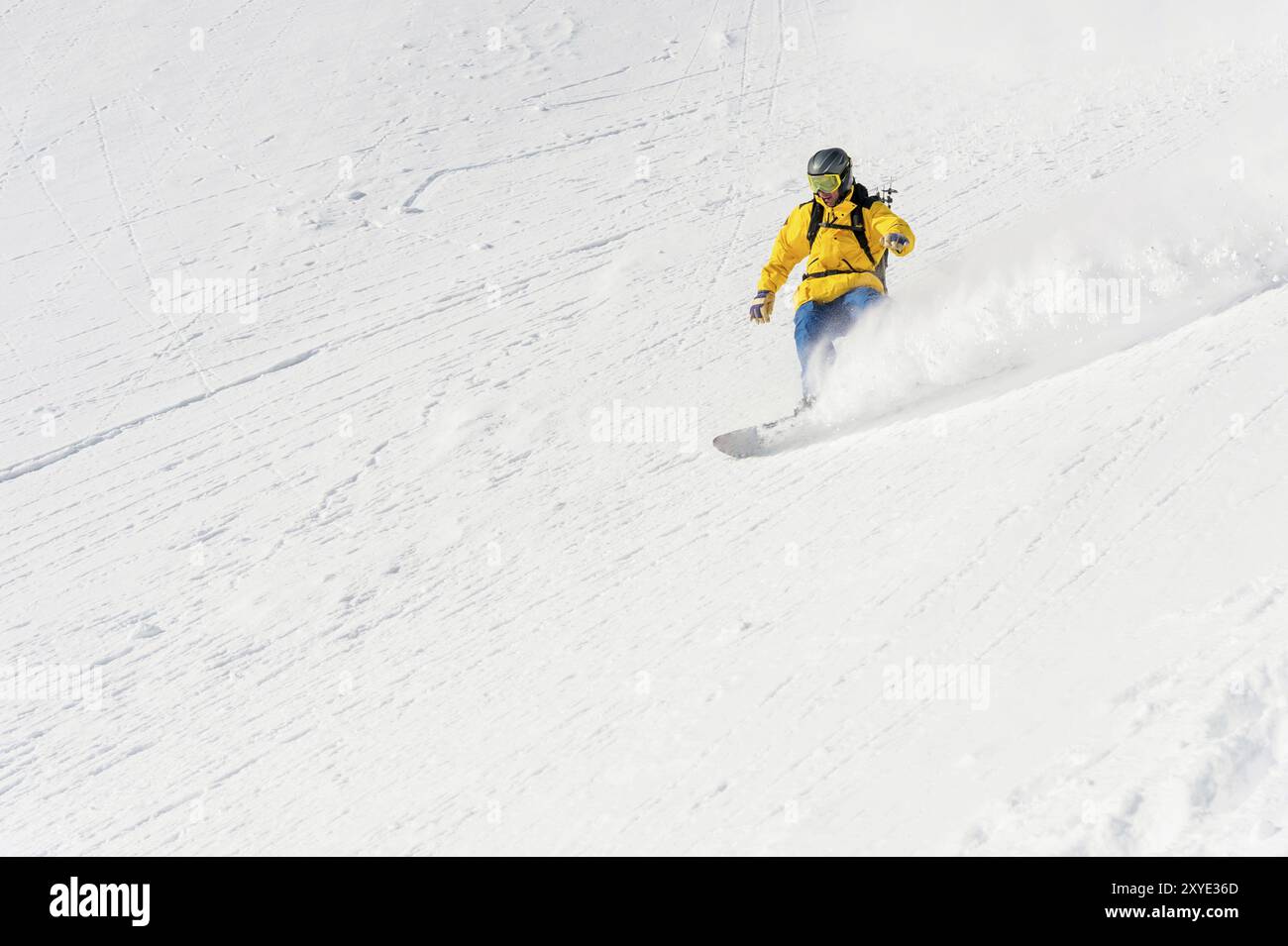A man a snowboarder freerider descends the backcountry at high speed ...