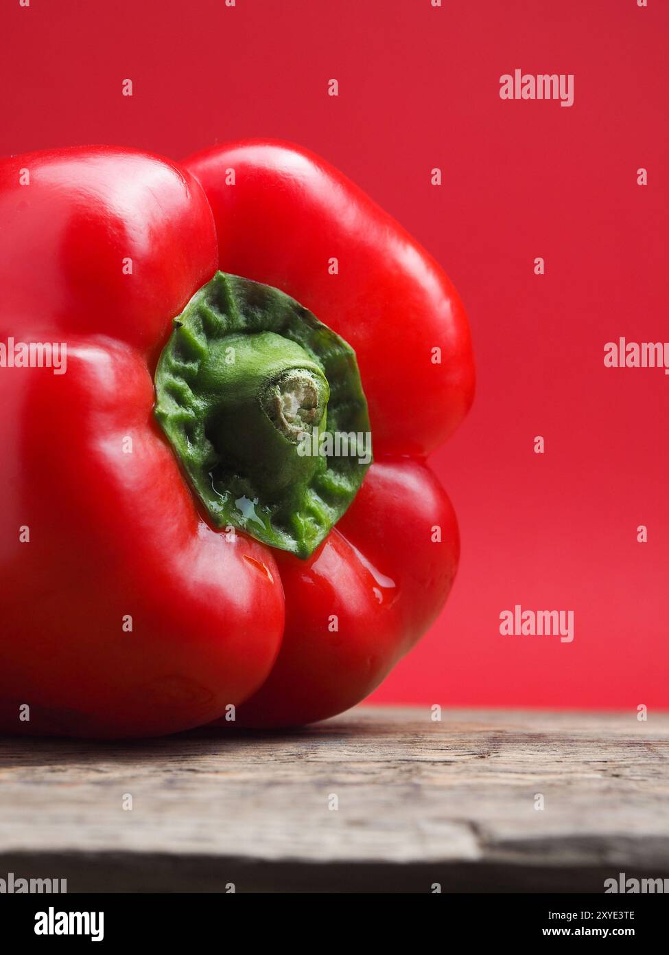 Fresh organic wet bell pepper on a rustic wooden kitchen table with ...