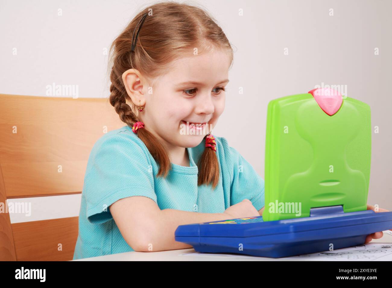 Cute little girl making homework with her computer Stock Photo - Alamy