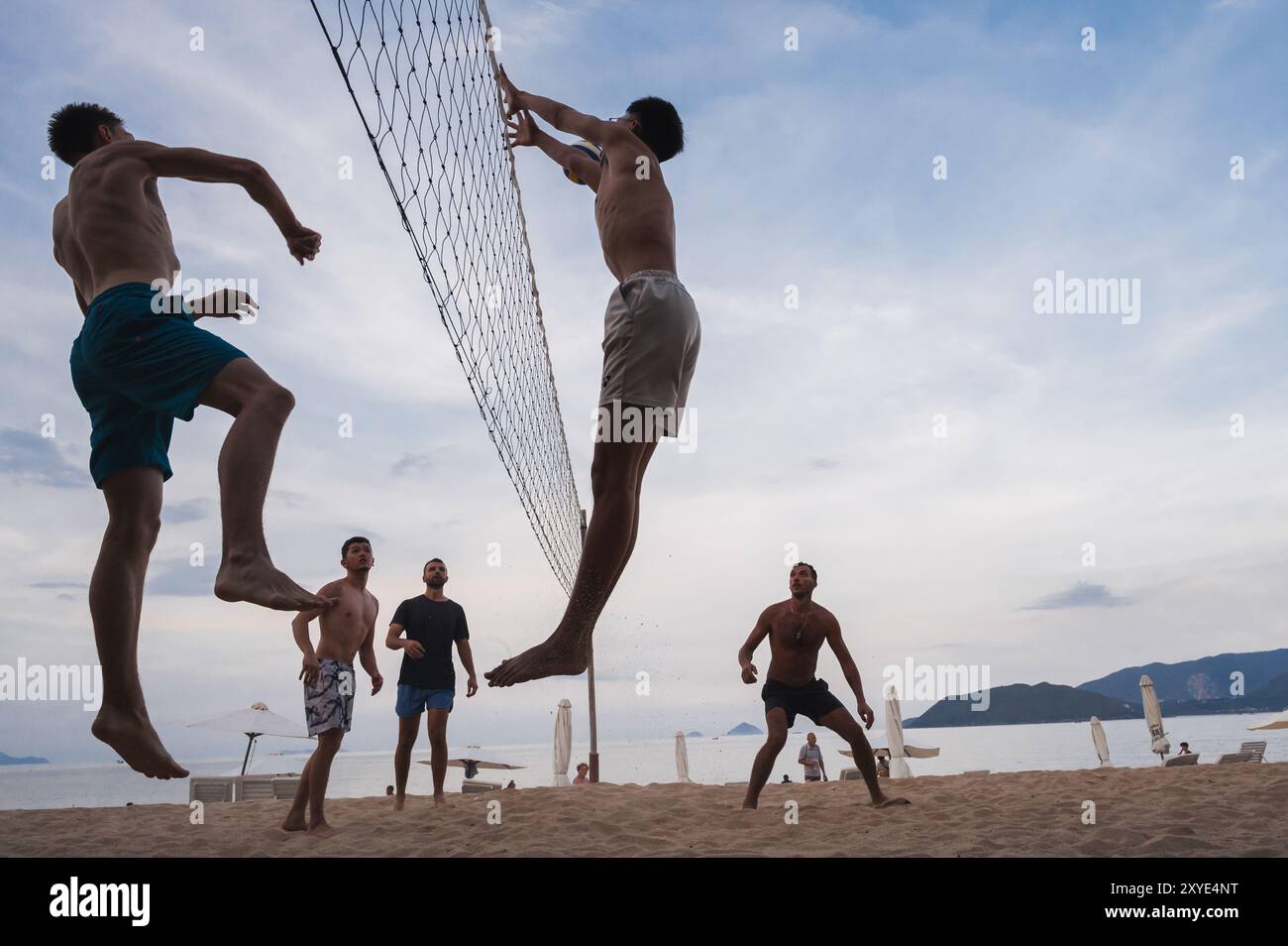 Teams with multinational players play beach volleyball by the sea in ...