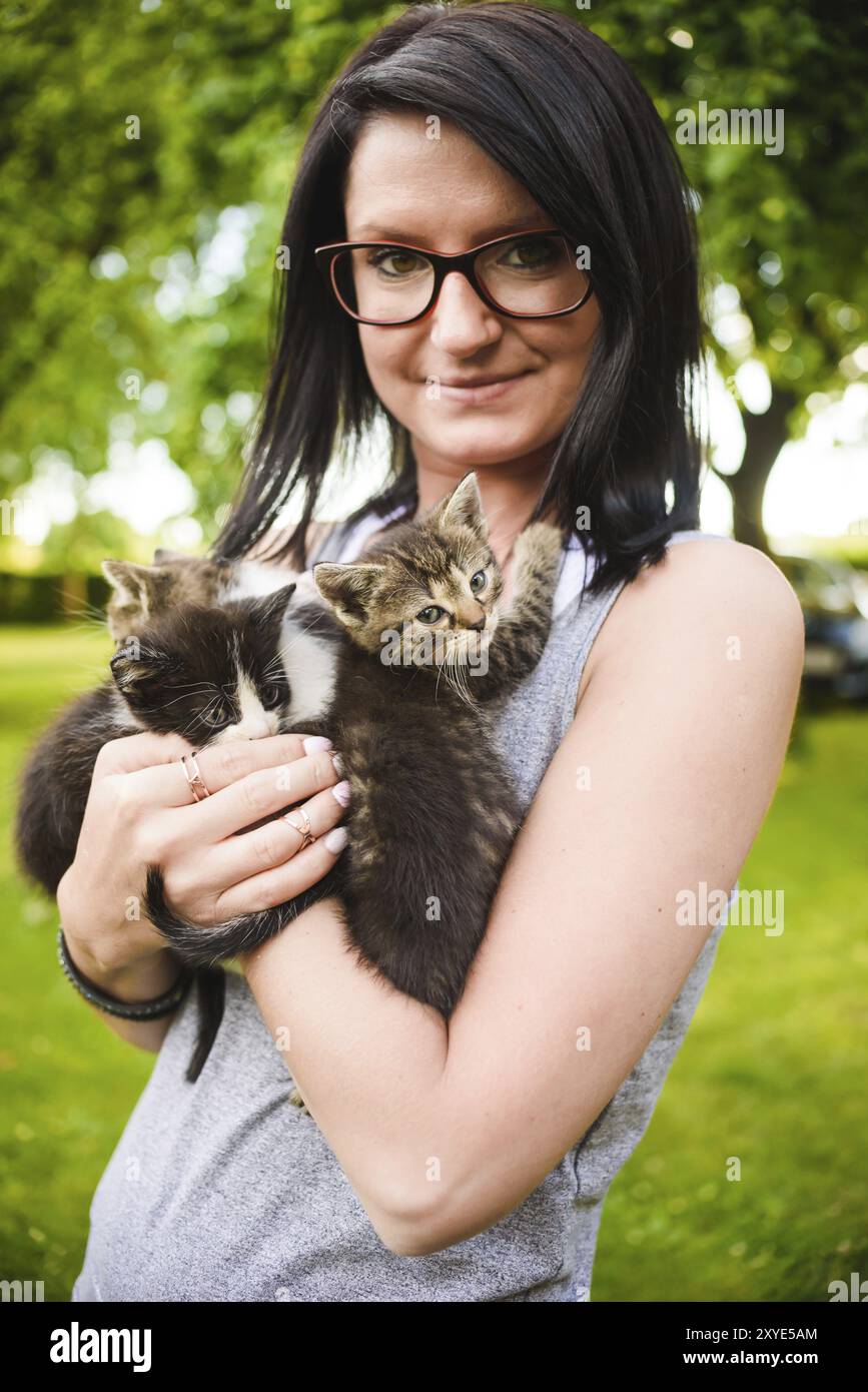 Young woman holding adorable kittens in arms. Pet concept Stock Photo ...