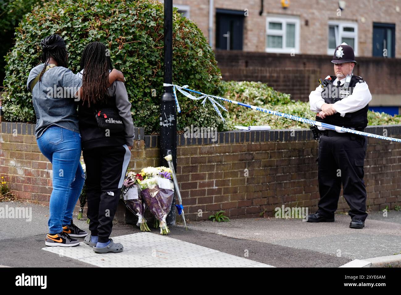A police officer stands by a police cordon as members of the public lay ...