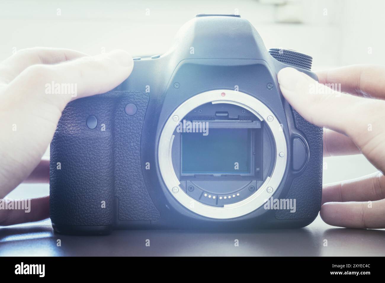 Hands of a photographer are touching a professional reflex camera, open ...