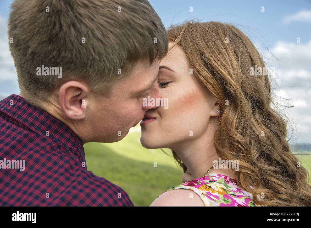 Young couple kissing against the background of a summer landscape close-up Stock Photo - Alamy