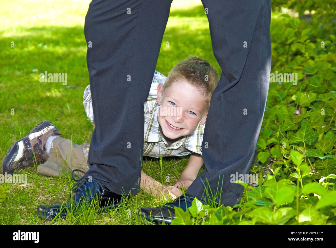Little boy between his father's legs Stock Photo - Alamy