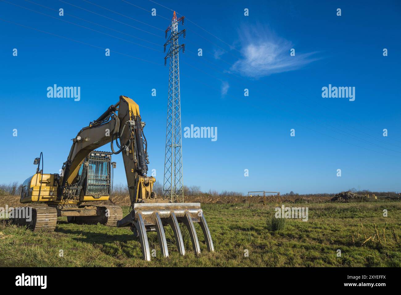 Special excavator with fork for clearing tree trunks in front of a high ...