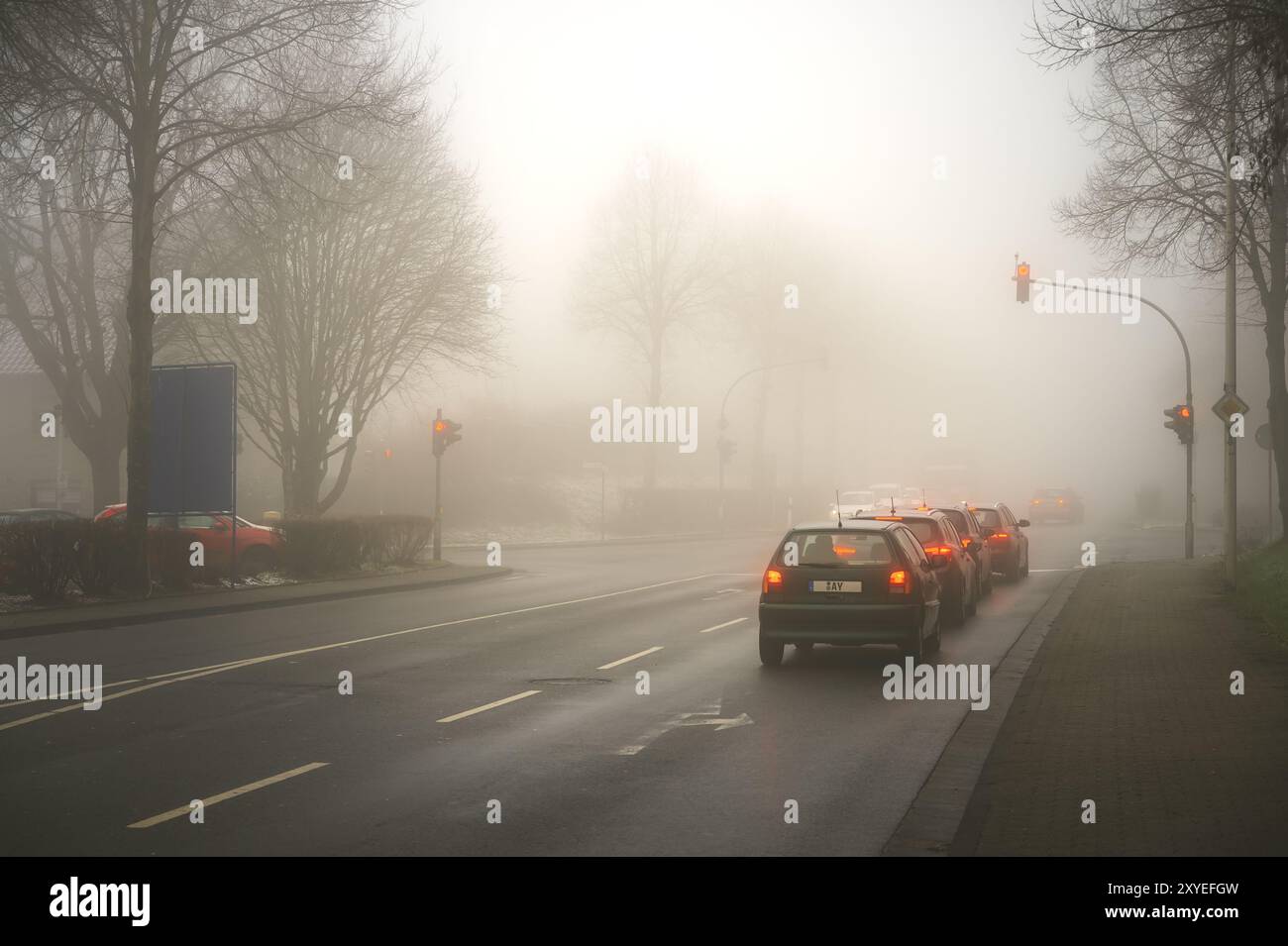 Car stops in the fog in front of a red light at an intersection Stock ...