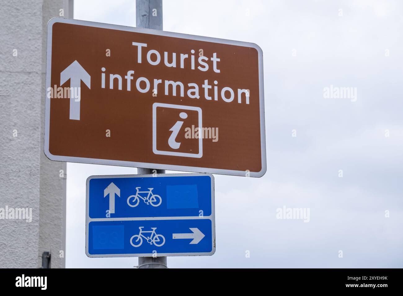 Brown tourist information sign with white lettering above blue cycle ...