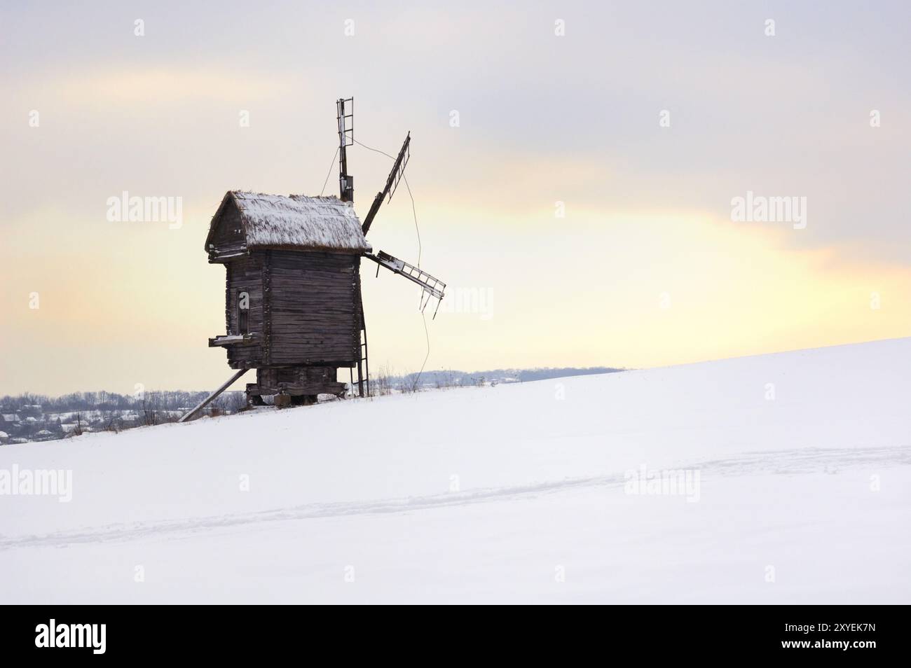 Ancient log windmill in a snow covered field lonely silhouette over ...