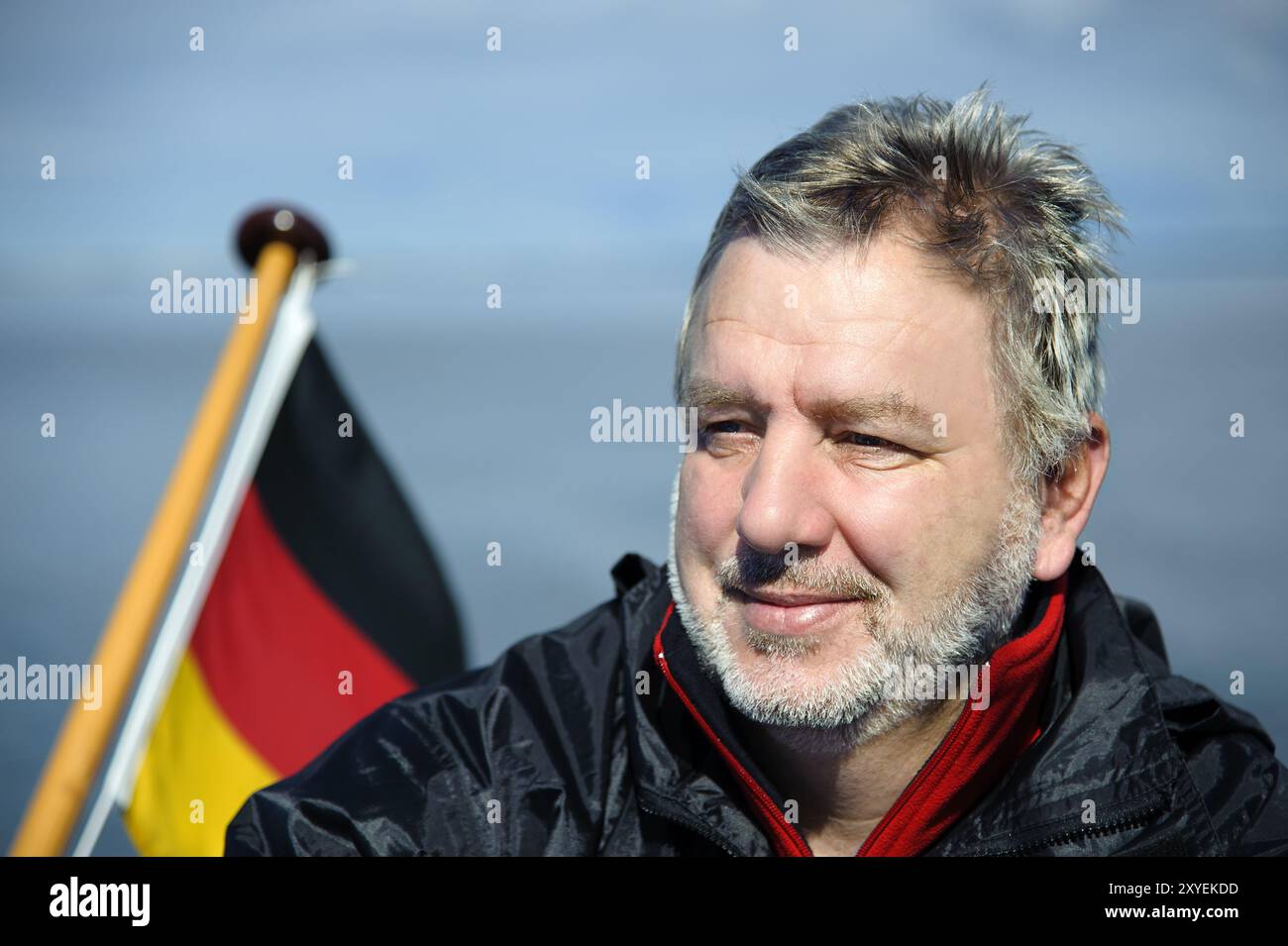 Man sitting next to a German flag Stock Photo - Alamy