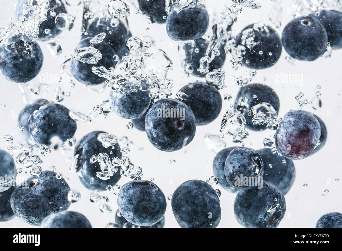 Blueberries sinking into water with air bubbles white background Stock ...
