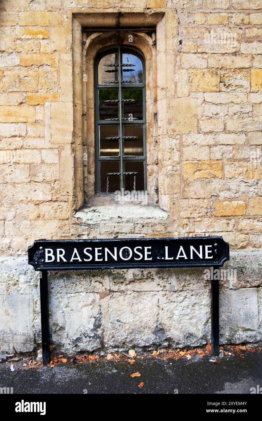 Brasenose Lane street sign on stone wall under vertical historic window ...