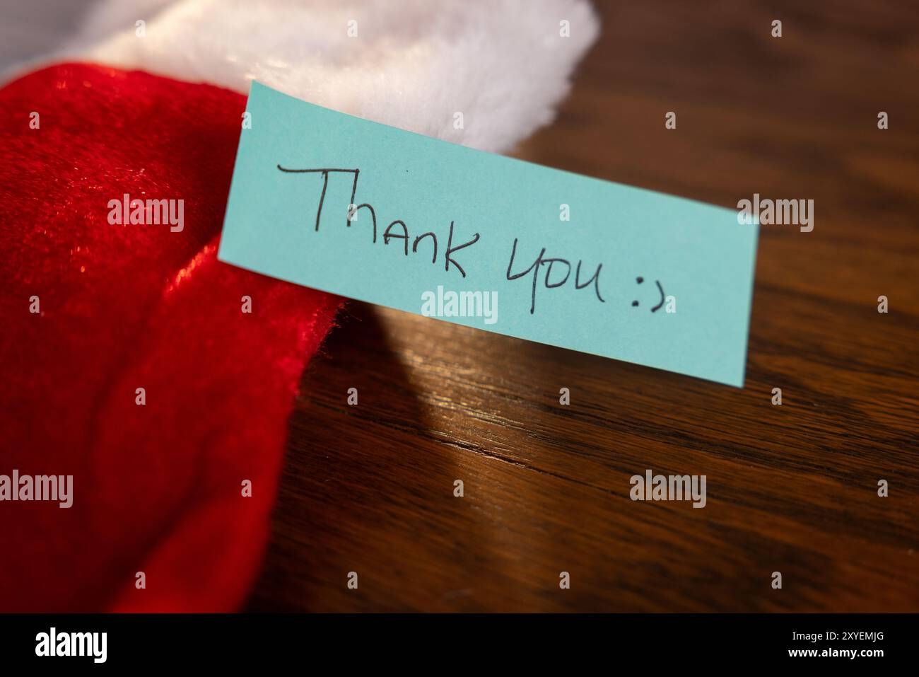 A blue note with the words "Thank You" written on it is placed on top ...