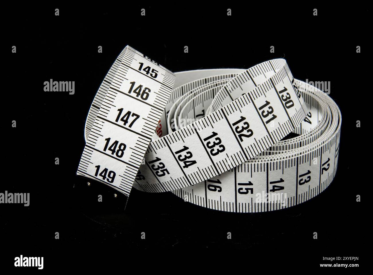Tape measure against a black background Stock Photo - Alamy