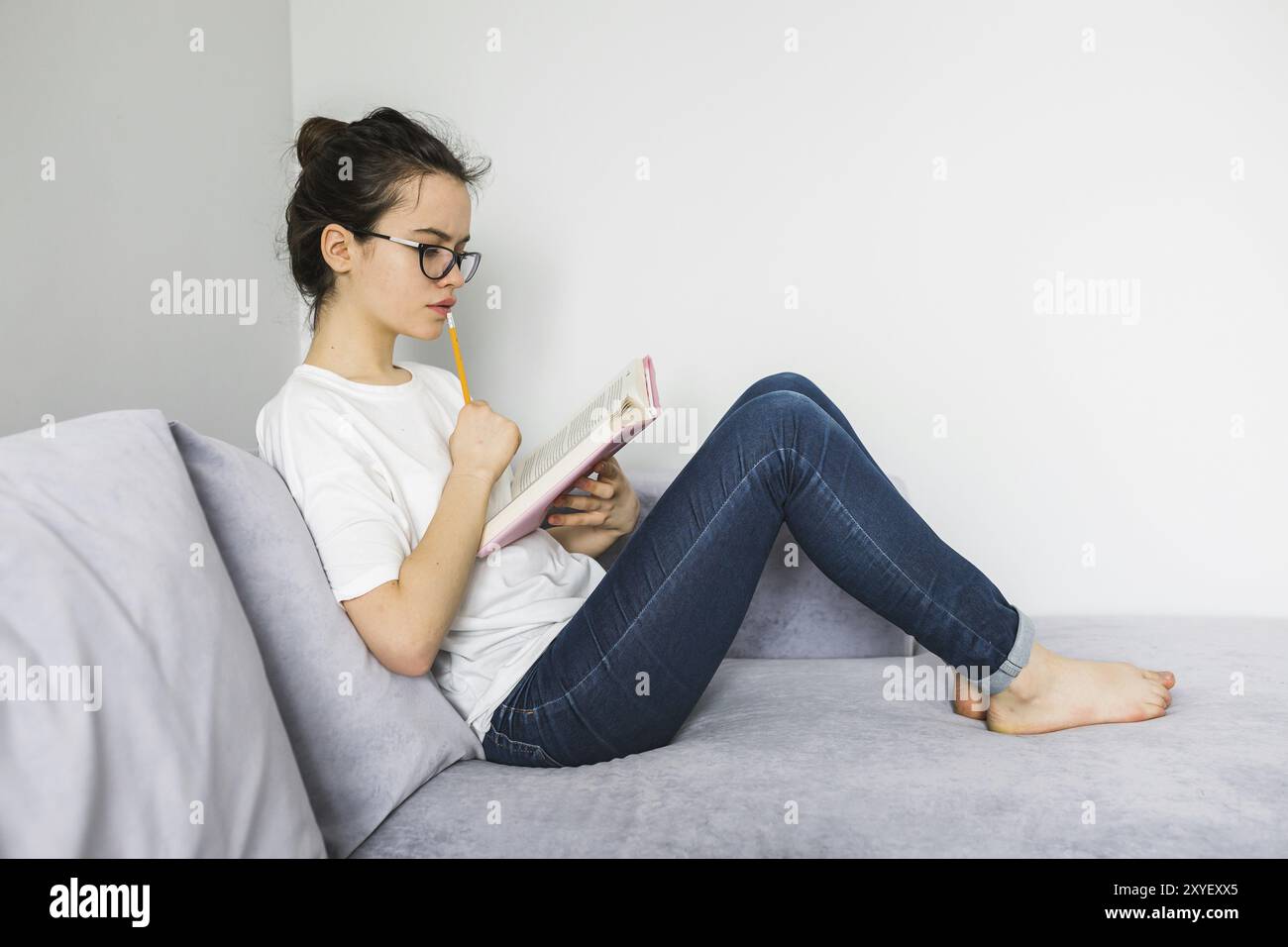 Barefoot woman reading thinking Stock Photo - Alamy
