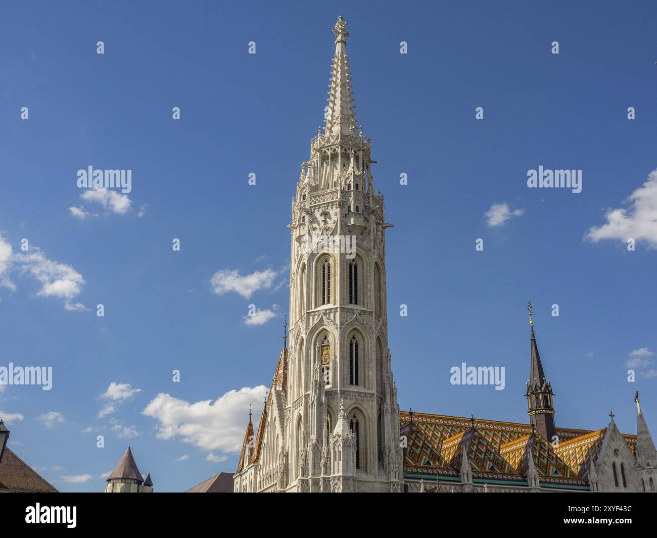 Impressive gothic church tower under a clear sunny sky with few clouds ...
