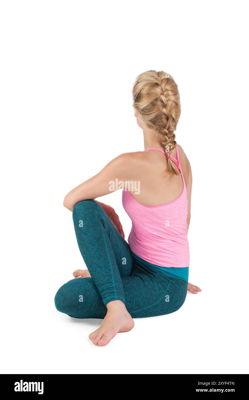 Image series: Full body view of a blonde woman in yoga twist position ...