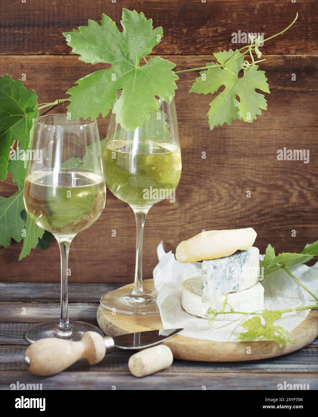 Still life with glasses of white wine, bottle and cheese Stock Photo ...