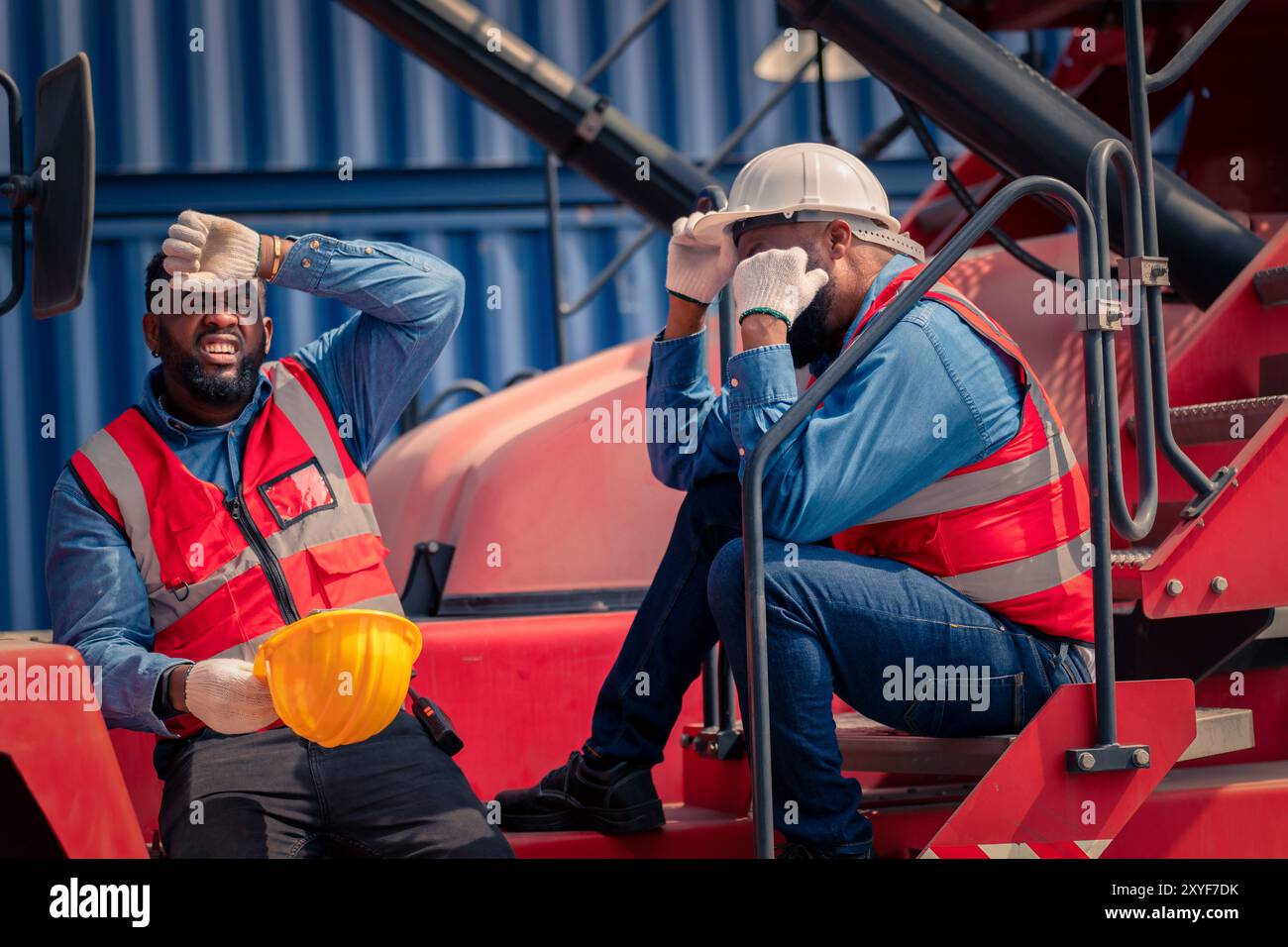 Two Engineer or foreman wears PPE sitting stress on container ...