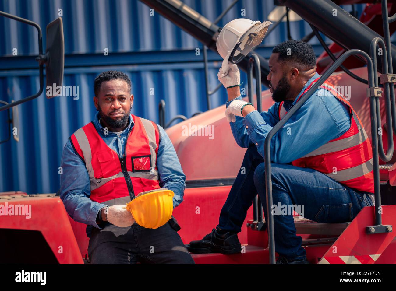 Two Engineer or foreman wears PPE sitting stress on container ...